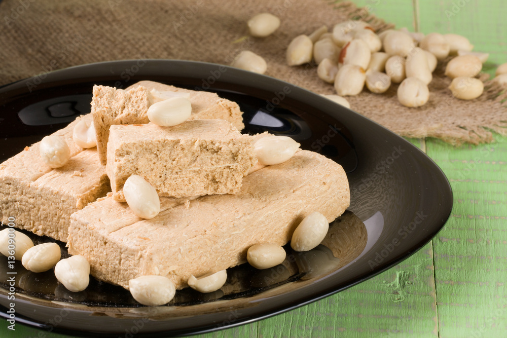 peanut halva in the plate on a green wooden background Stock Photo ...
