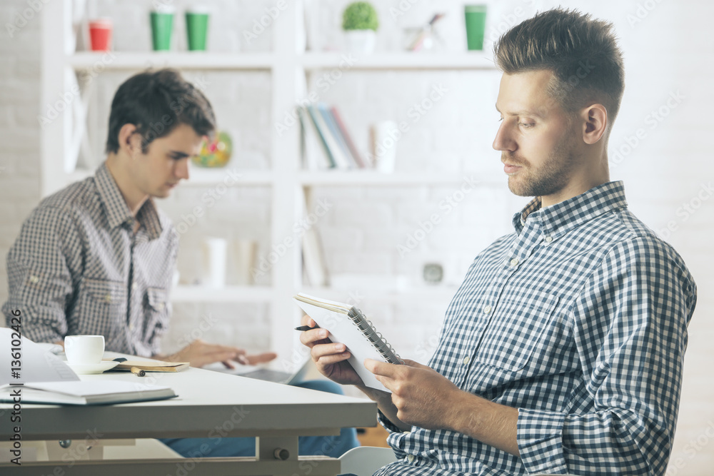 Handsome man writing in notepad Stock Photo | Adobe Stock