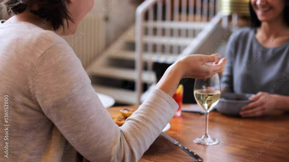 women having dinner and talking at restaurant Stock Video | Adobe Stock