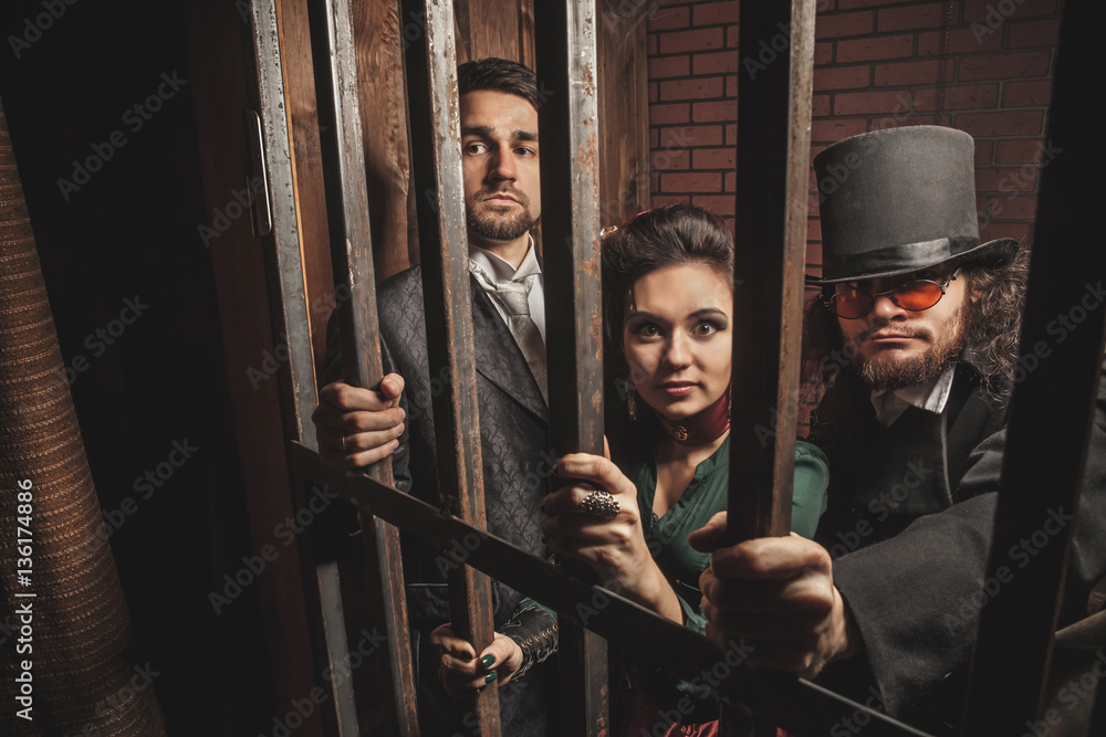 Two gentlemen and a lady behind bars in the prison. Stock Photo | Adobe ...
