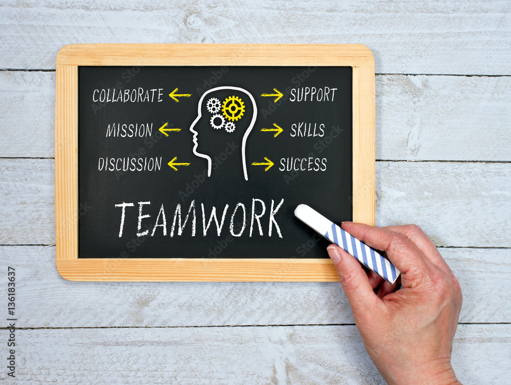 Teamwork concept chalkboard with female hand and chalk on wooden ...