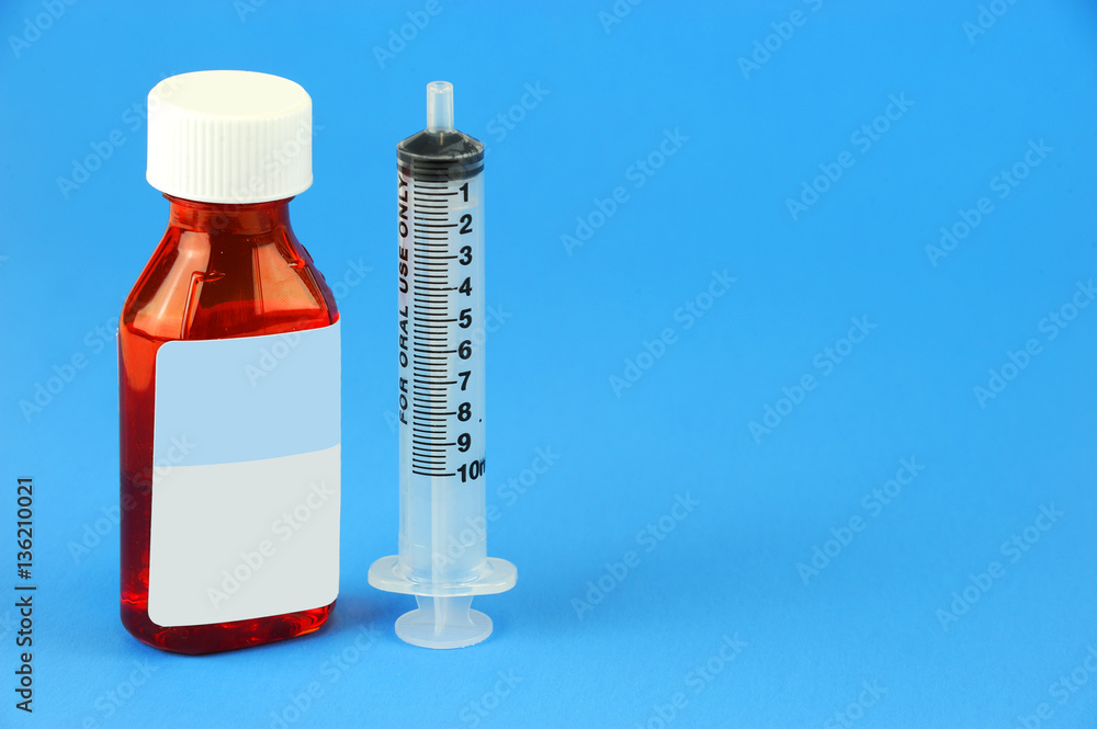 Prescription medicine bottle and oral syringe for baby isolated on blue ...
