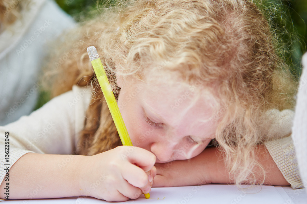 Kind malt und zeichnet mit einem Stift Stock Photo | Adobe Stock