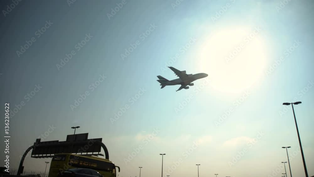 The plane flies low over a busy highway with cars. The plane comes in ...