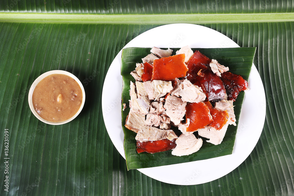 Chopped parts of the delicacy lechon or suckling pig on a banana leaf ...