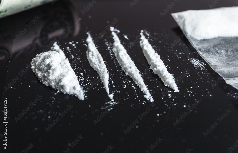 Cocaine drug addiction. Lines of cocaine on black background closeup ...