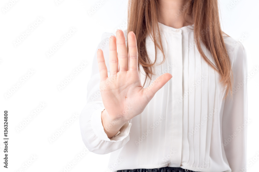 young girl in white shirt stretched one hand forward and shows Palm ...