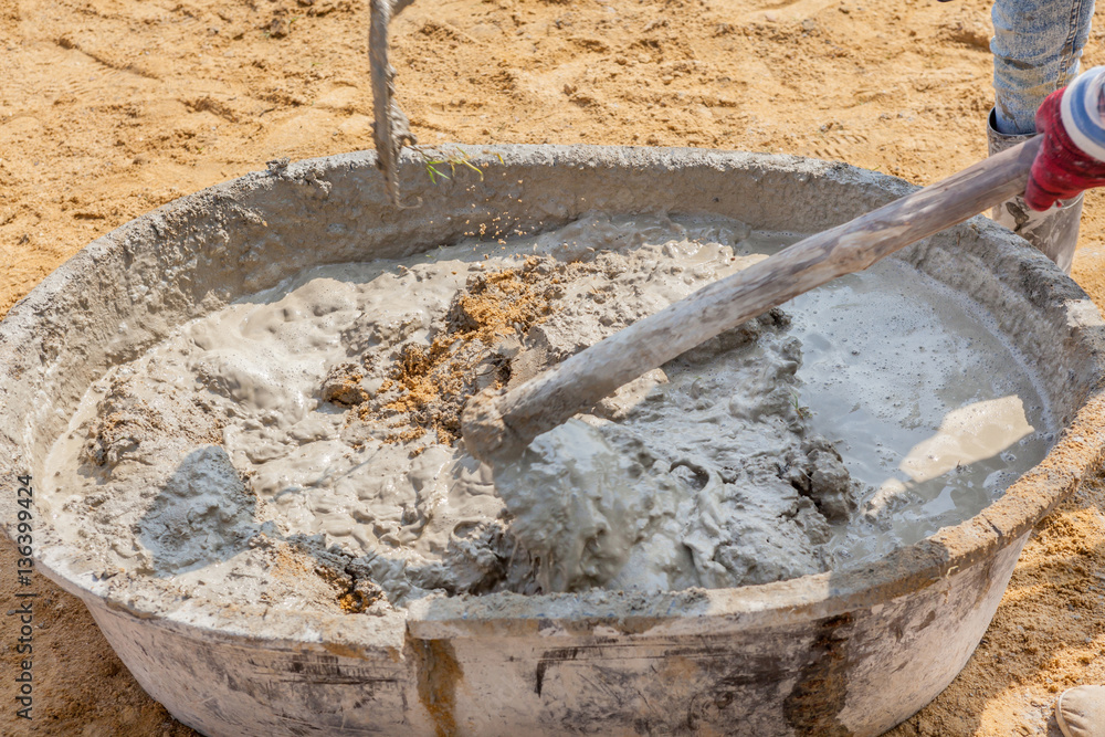 Concrete workers mixing and stirring the cement and sand in salv Stock ...