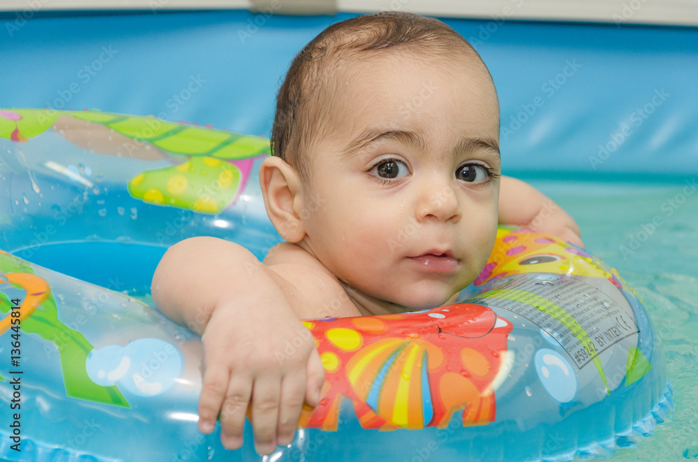 Foto Stock Baby relaxing in the swimming pool | Adobe Stock
