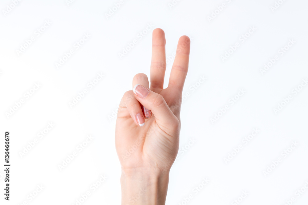 female hand showing the gesture with raised up two fingers is isolated ...