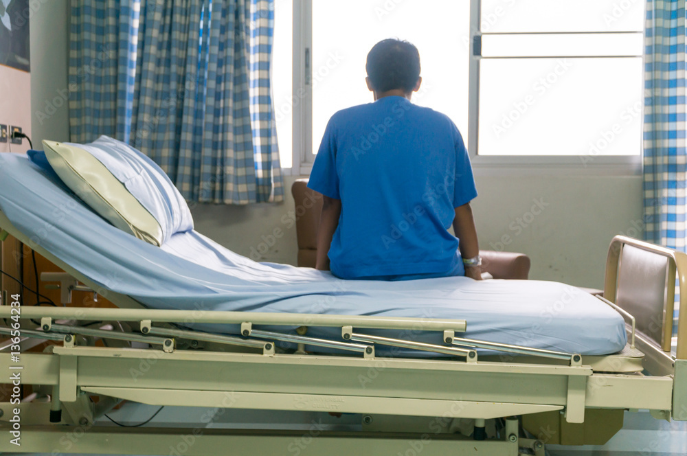 Man Patient Sitting On Hospital Bed Looking Throught The Windows Stock
