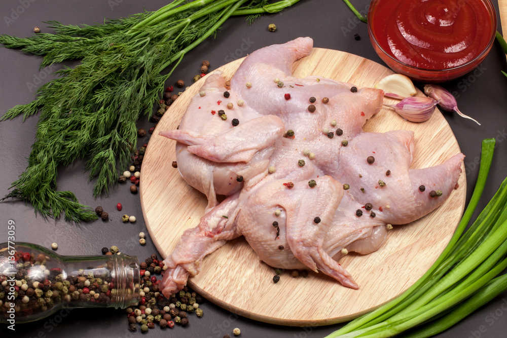 raw chicken carcass with peppercorns and greenery on the cutting board ...