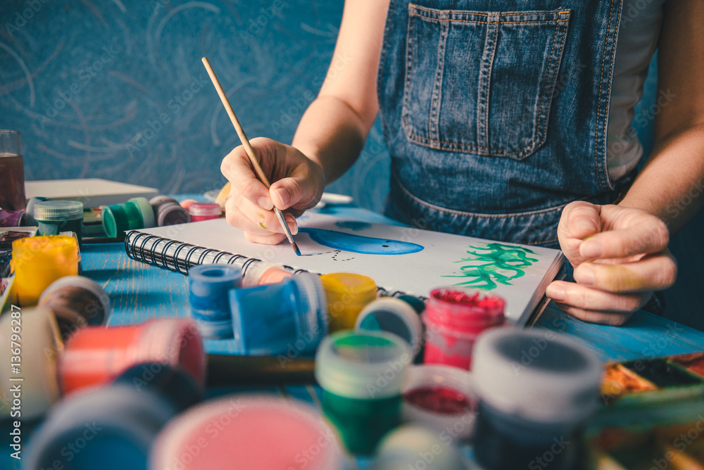 Pretty smiling young woman drawing a picture with poster paint Stock ...