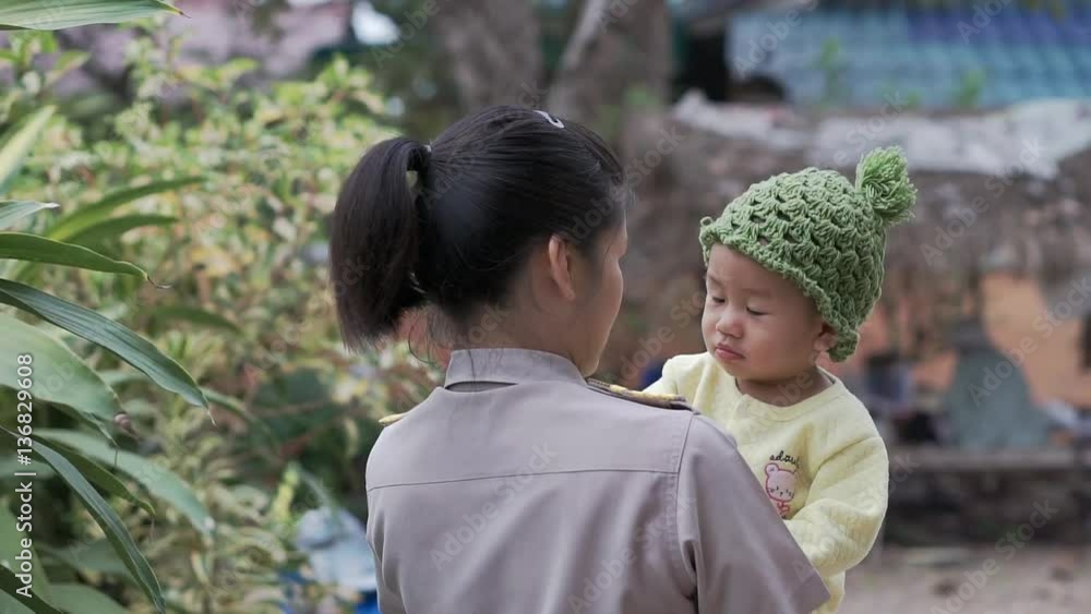 Asian Mother in Thai officer uniform holding her 10 months year old ...