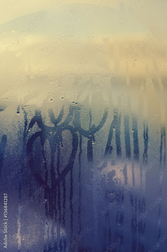 Funny drawing painted on misted glass background. closeup image of cold ...