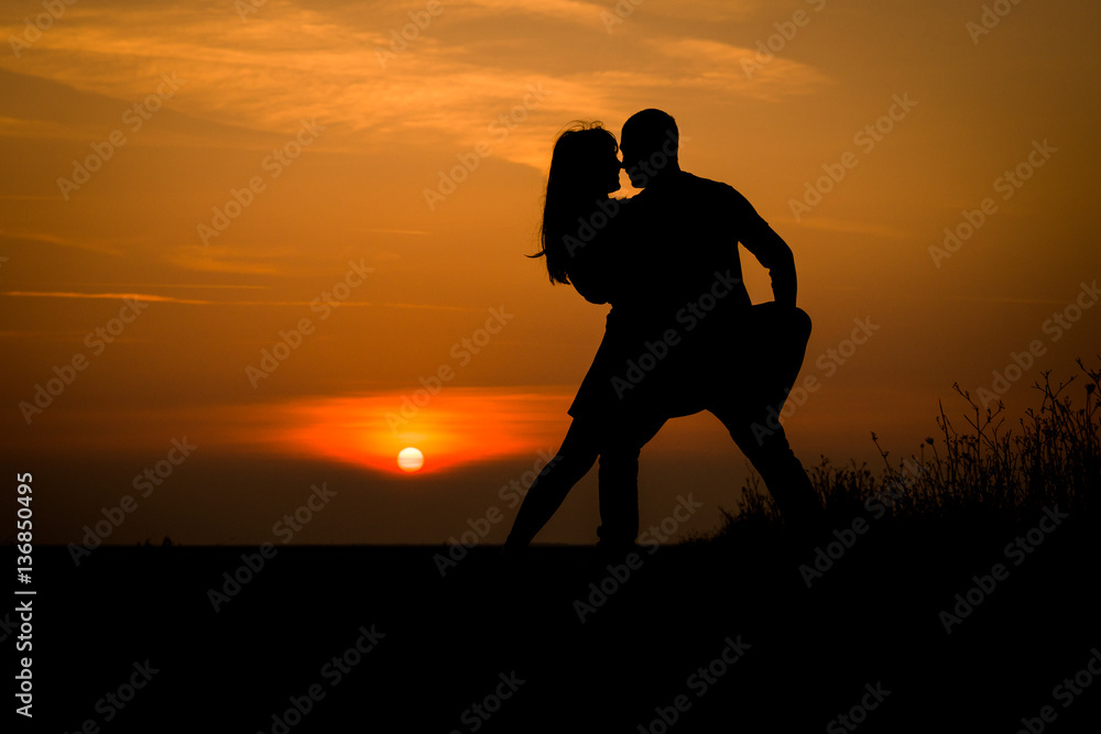 silhouette teenager lovers couple with sun between on sunset dusk sky ...