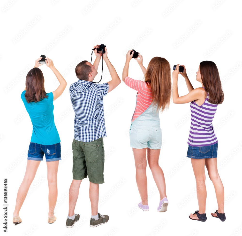 Back view group of people photographed attractions. Rear view team ...