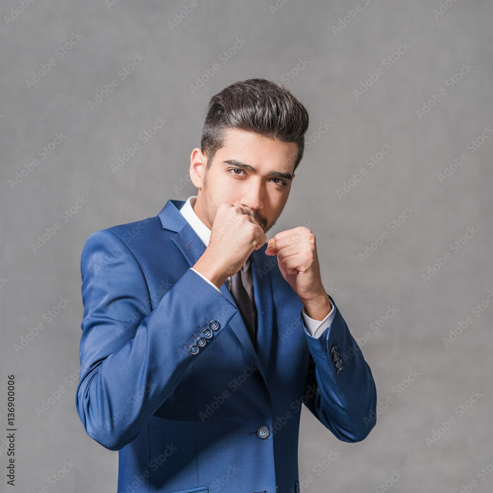 Young attractive man in a blue suit standing in a fighting stance on a ...