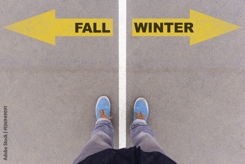 Fall vs Winter text arrows on asphalt ground, feet and shoes on Stock ...