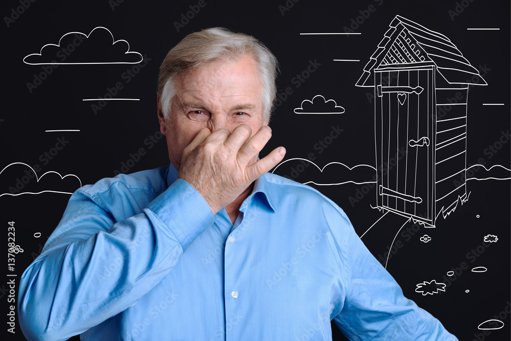 Cheerless senior man putting his hand to the nose Stock Photo | Adobe Stock