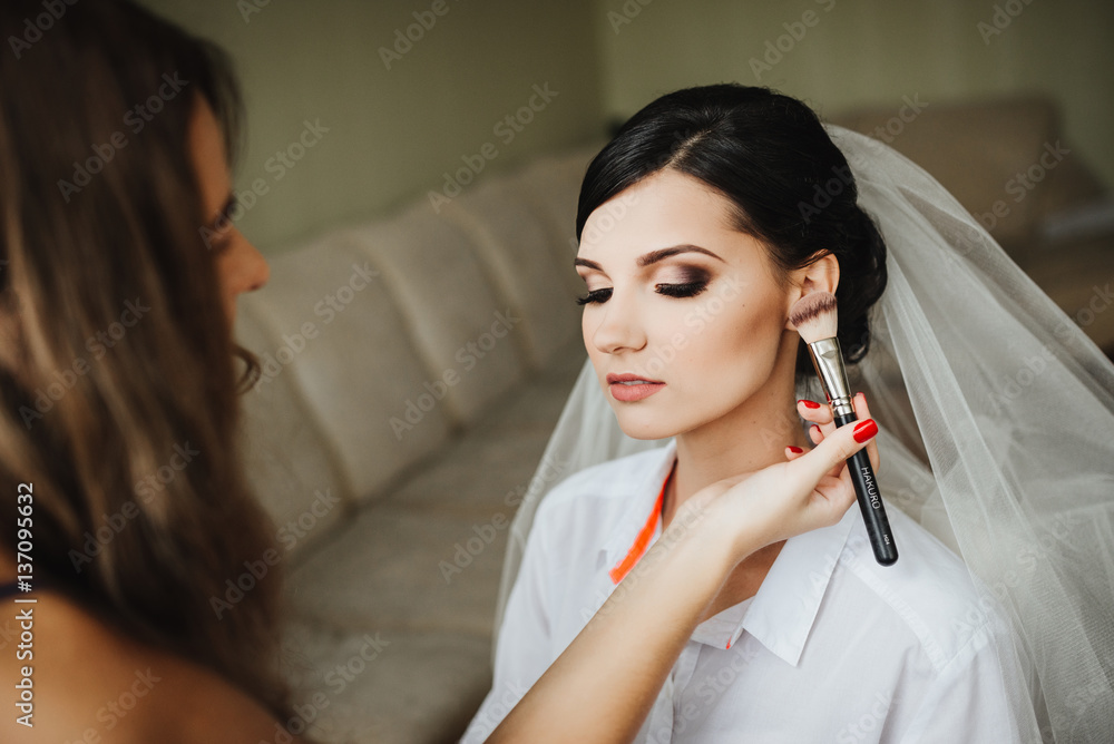 Beautiful young bride with wedding makeup and hairstyle in bedroom ...