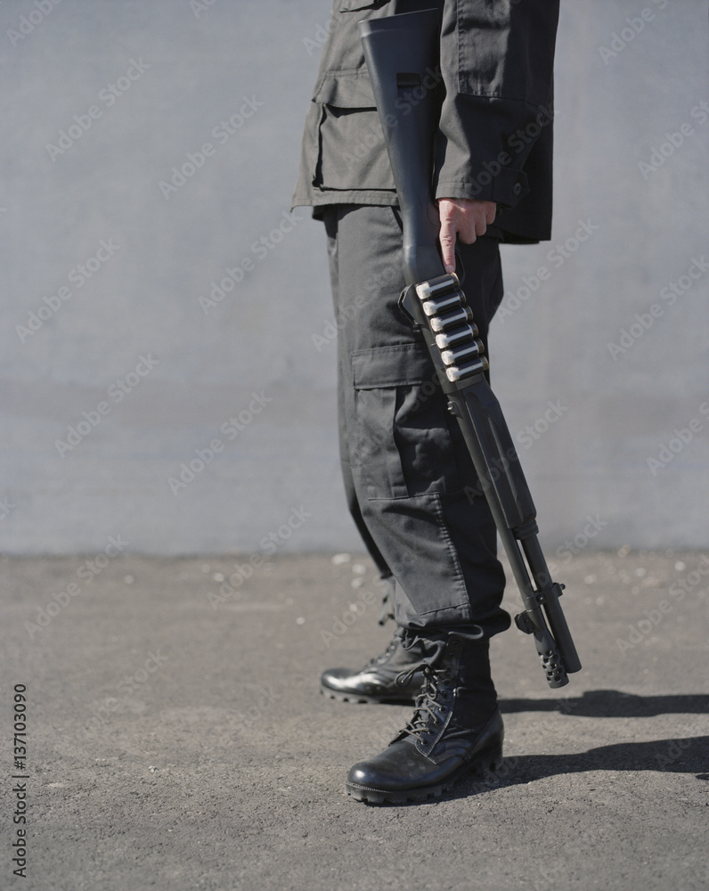 Low section of man holding shotgun Stock Photo | Adobe Stock