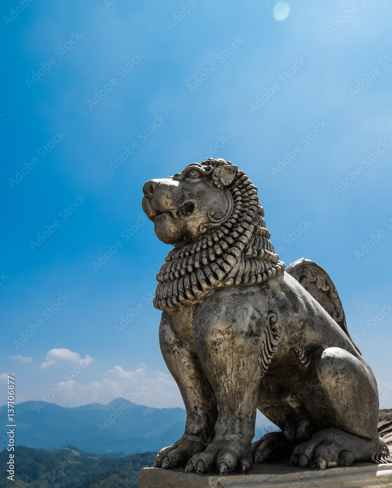 Brave Lion Posture sitting Statue on a mountain view top cliff with ...