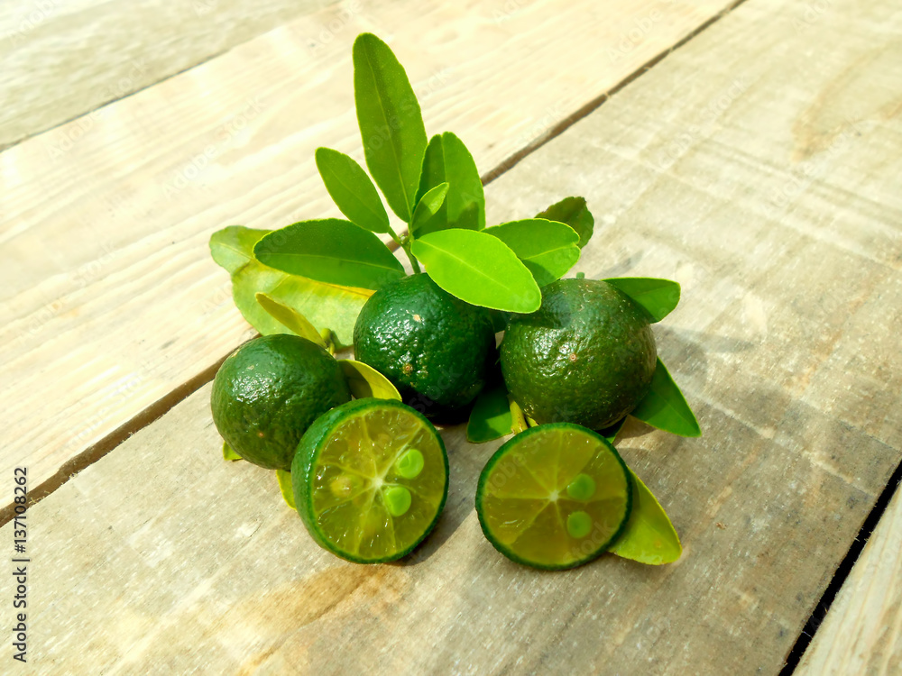 Calamansi isolated on wooden background Stock Photo | Adobe Stock