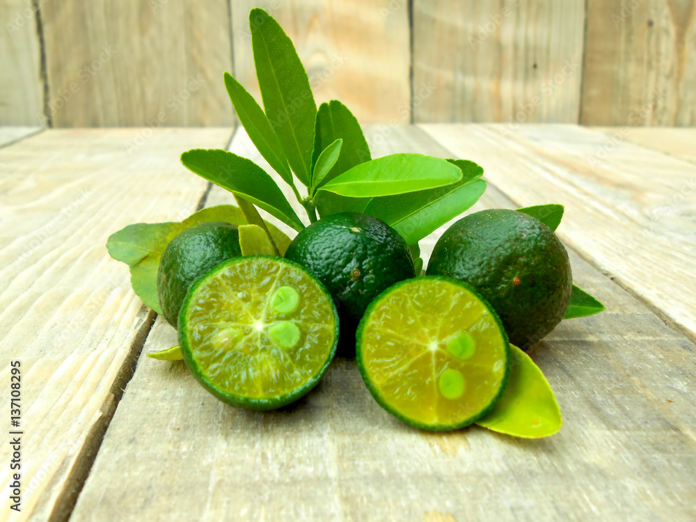 Calamansi isolated on wooden background Stock Photo | Adobe Stock