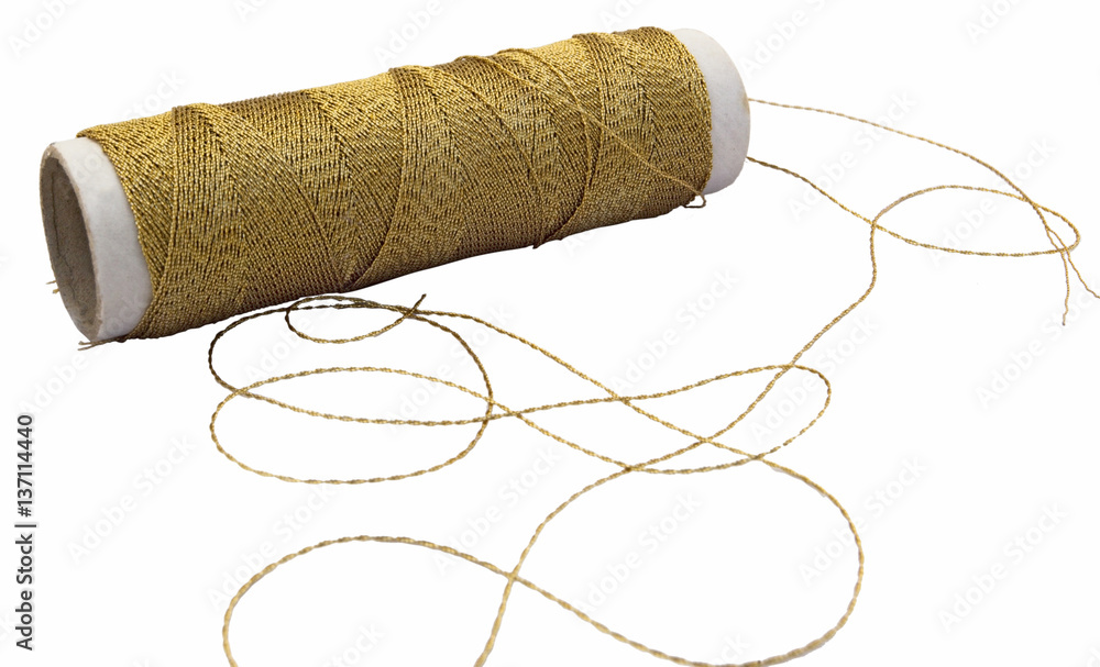 Spool of gold thread. Isolated. Stock Photo | Adobe Stock