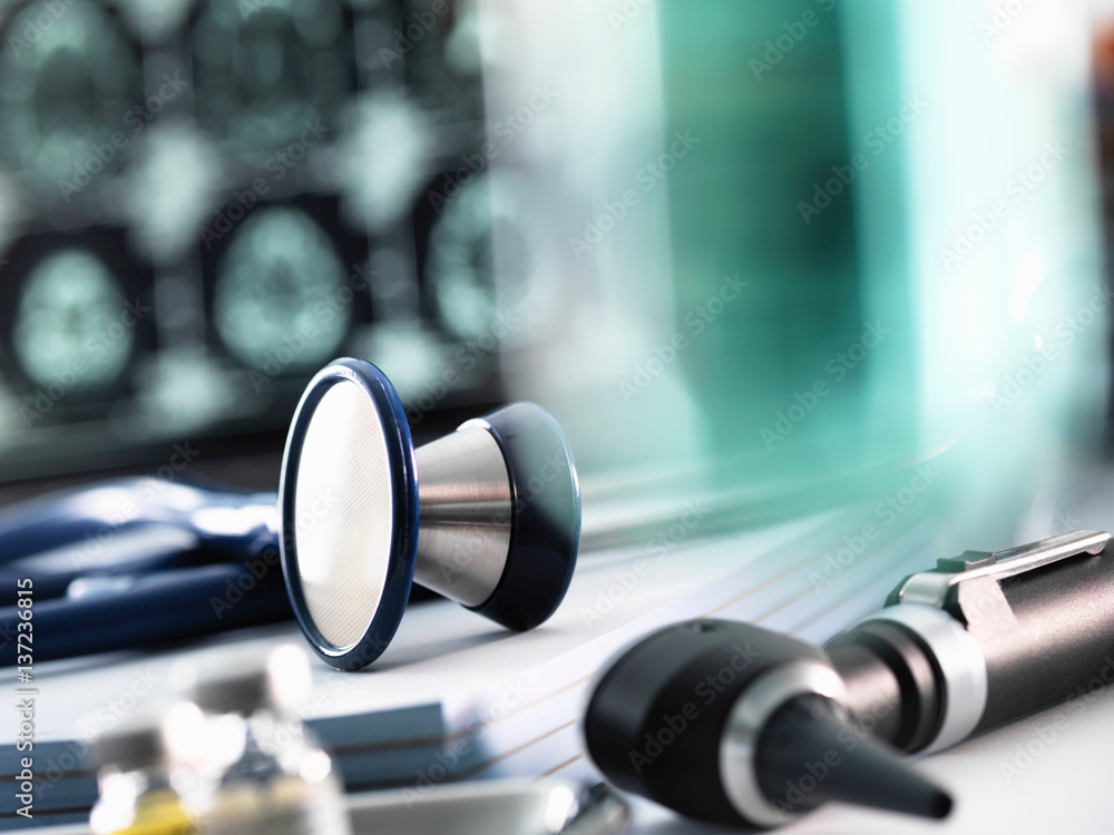 Doctor's desk with stethoscope sitting on prescription pads, otoscope ...