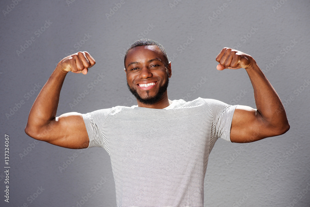 young smiling man flexing arm muscles Stock Photo | Adobe Stock