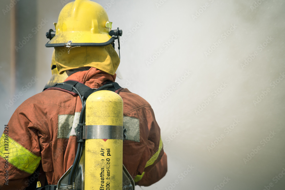 firefighter fire fighting suround with dark smoke Stock Photo | Adobe Stock