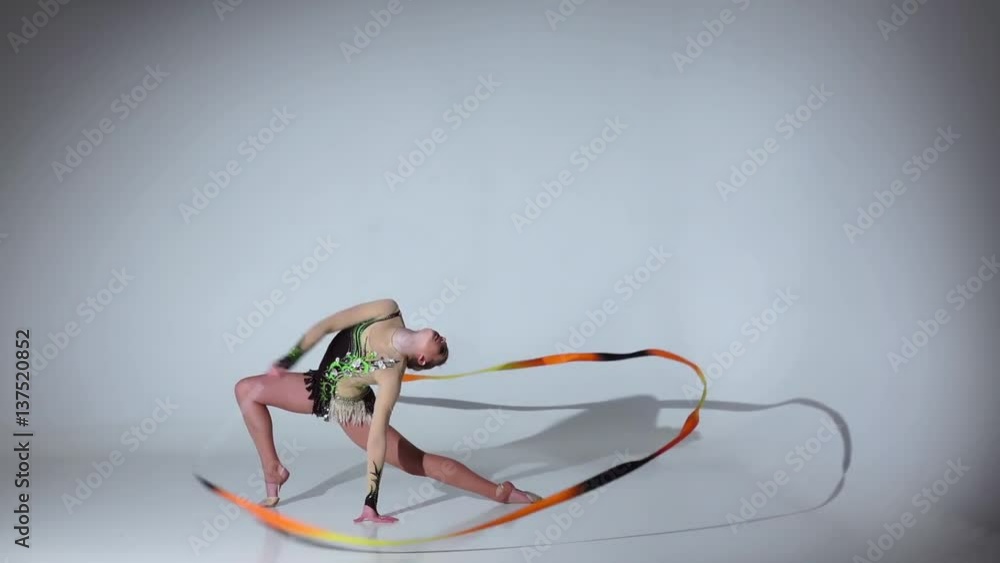 Rhythmic gymnast sit on one leg on the string. White background. Slow ...