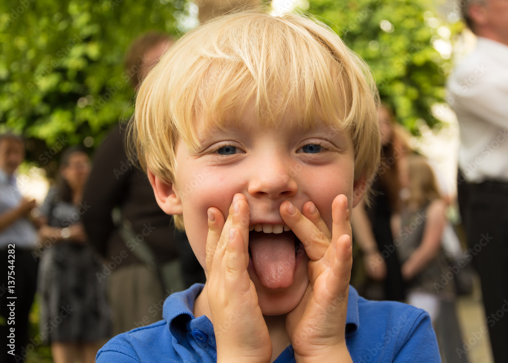 kleiner Junge streckt fröhlich die Zunge raus in die Kamera Stock Photo ...