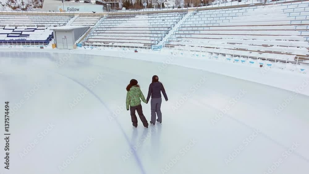 Aerial view of ice skating two women friends outdoor, ice rink Medeo ...