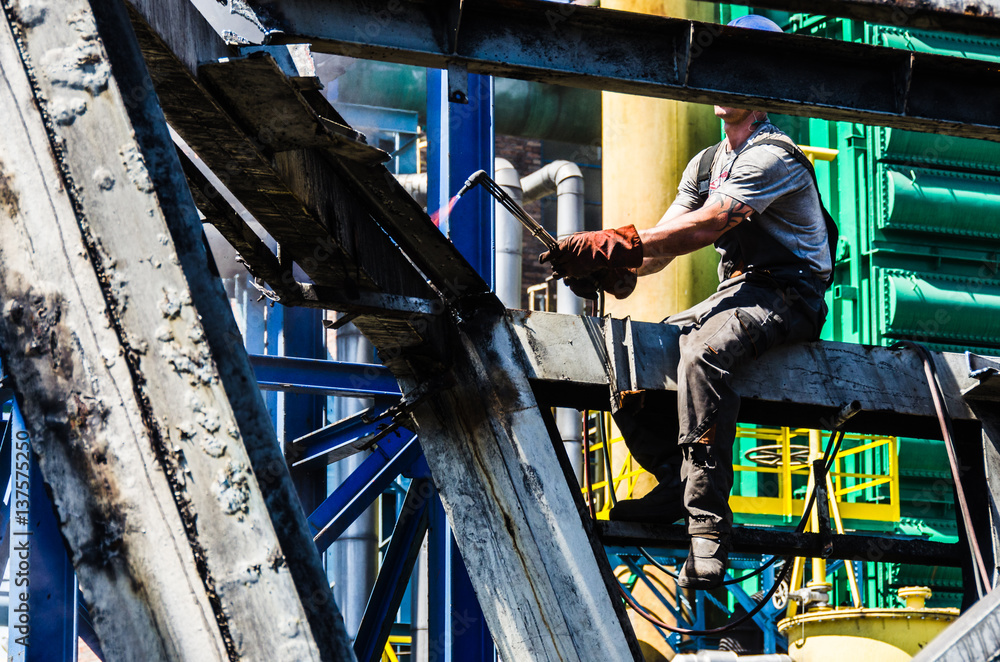 Cutting steel structure. Work at height. Man working on the demolition ...