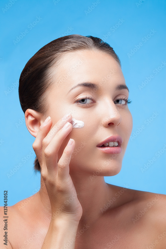 Jeune femme applique de la crème hydratante sur son visage Stock Photo ...