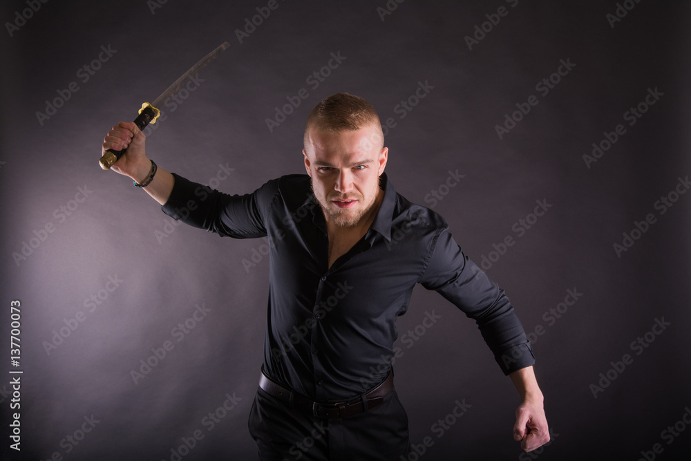 Aggressive young man holding katana sword Looking at the Camera.Against ...
