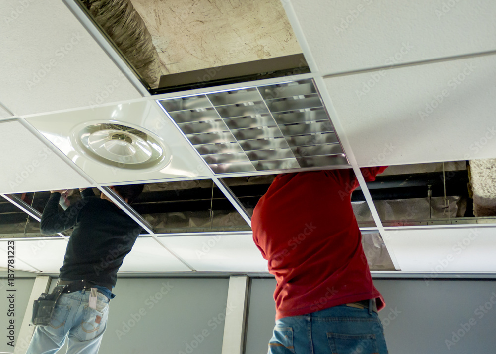 Builders putting or repairing up a suspended ceiling Stock Photo ...