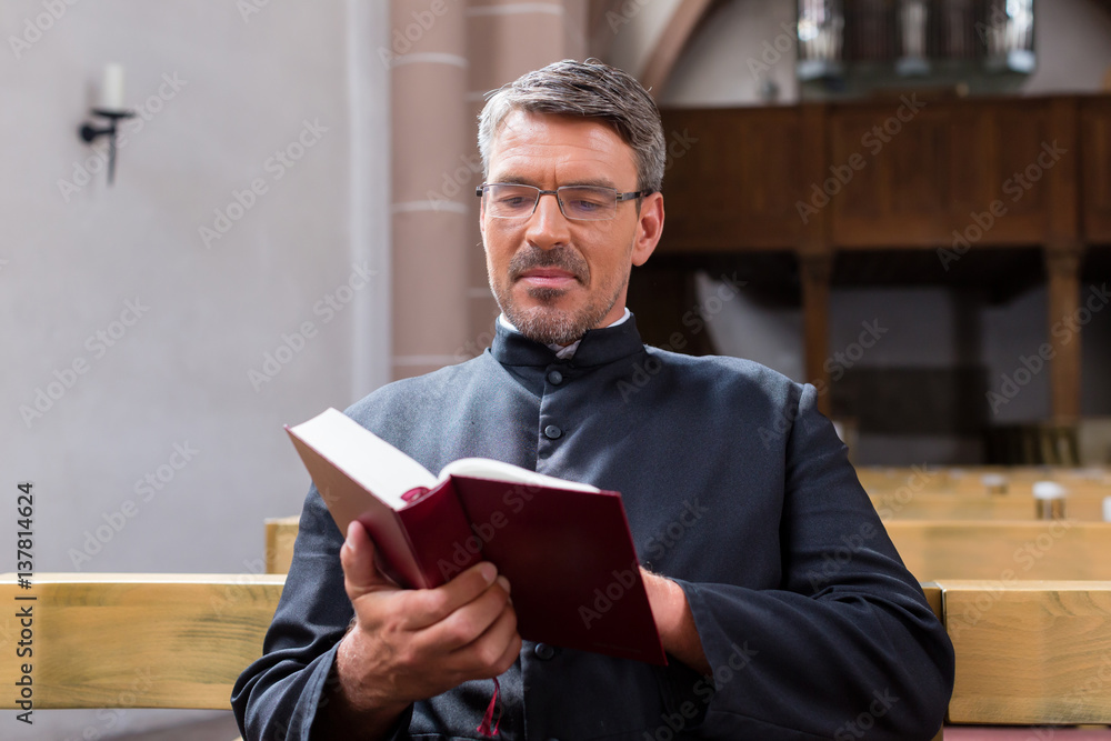 Priester oder Pfarrer sitzt in Kirche liest die Bibel Stock-Foto ...