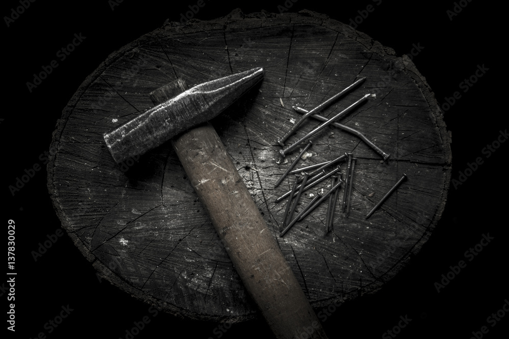 hammer with wooden handle with many iron hobnails on the wooden stub ...