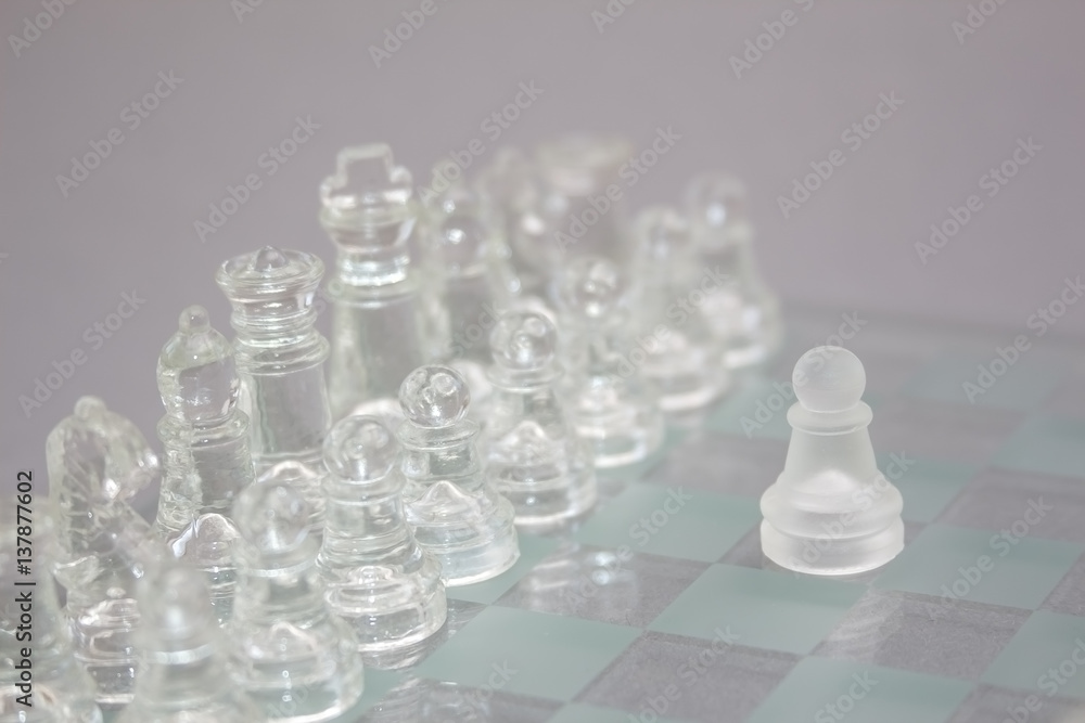 glass chess on a gray background. Stock Photo | Adobe Stock