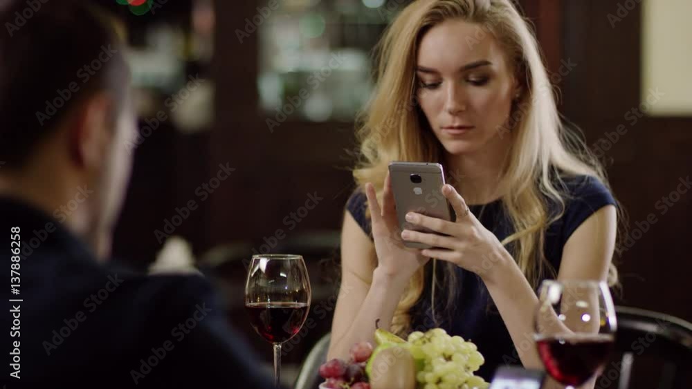 Young couple using smartphone during dating in restaurant Stock Video ...