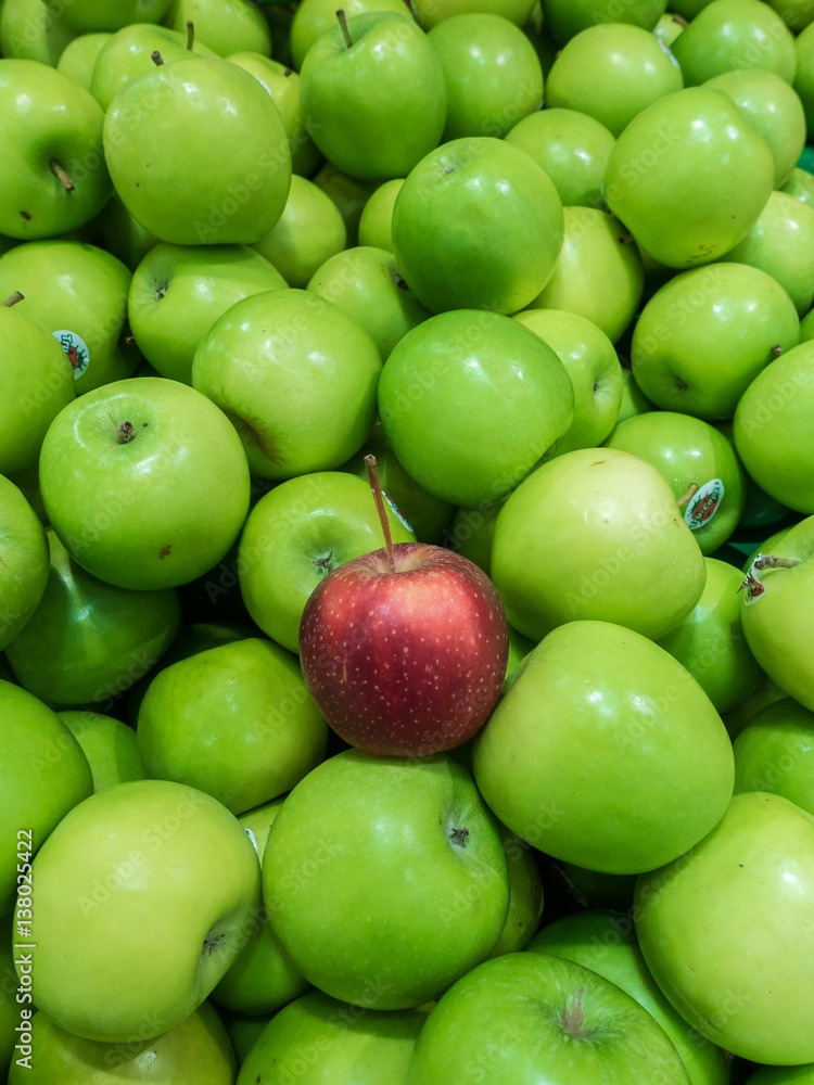 Red apple among green apples Photos | Adobe Stock