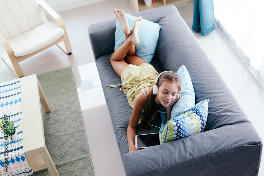 Tween girl relaxing on couch at home Stock Photo | Adobe Stock