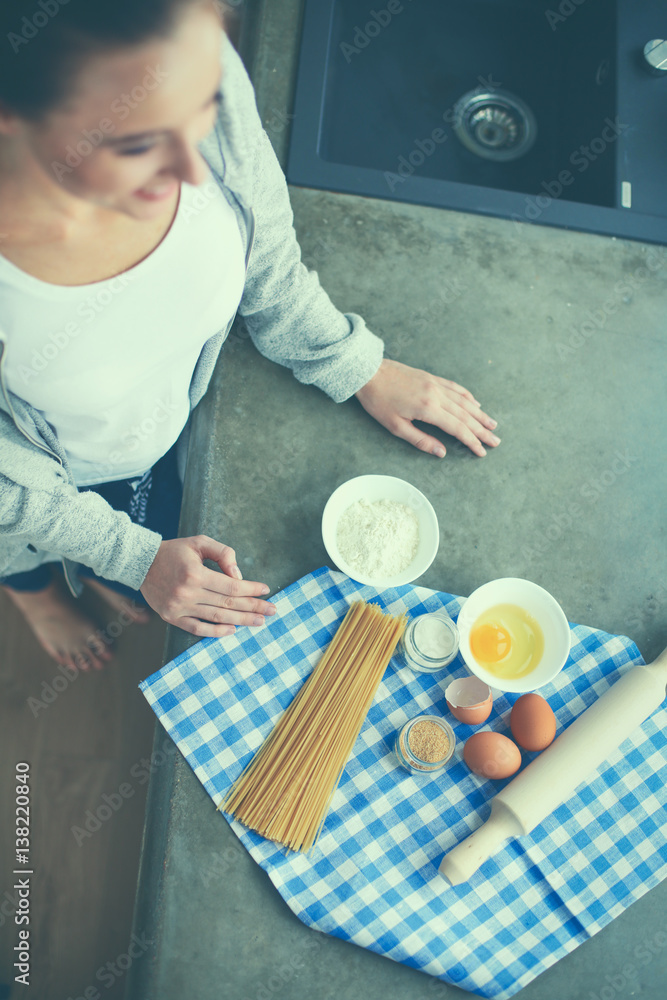 Beautiful woman cooking cake in kitchen standing near desk Stock Photo ...