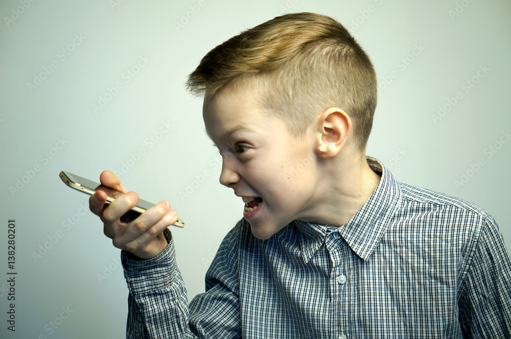 Angry teenage boy talking on smartphone Stock Photo | Adobe Stock