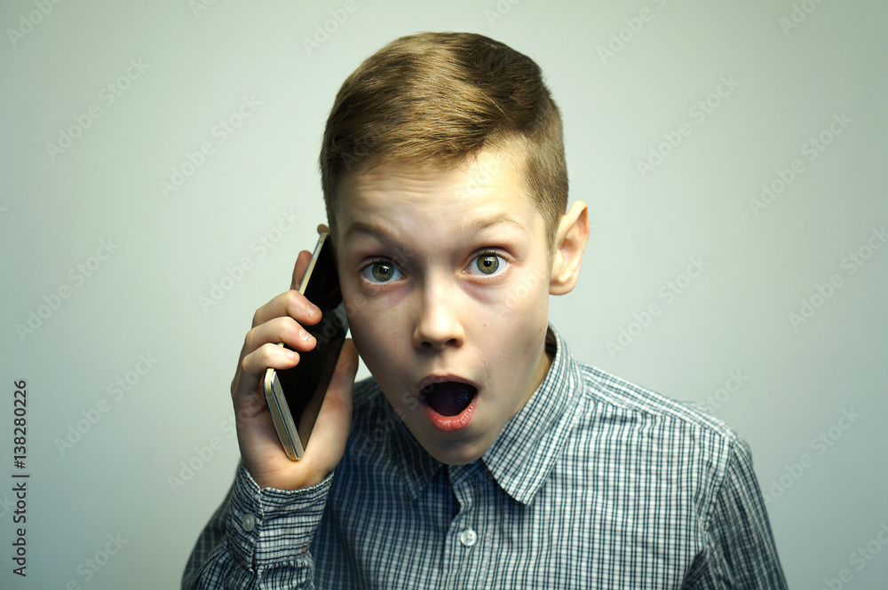 Angry teenage boy talking on smartphone Stock Photo | Adobe Stock