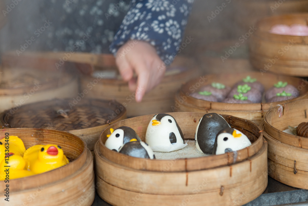 Chinese steamed buns in penguin and duck animal shapes with a shallow ...